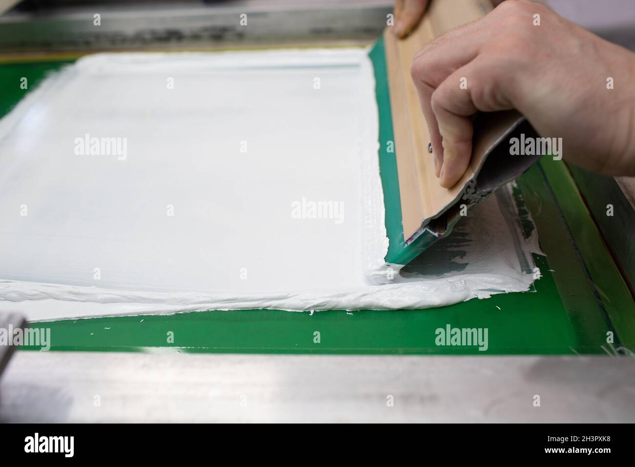 Serigraphy silk screen print process at clothes factory. Frame ...