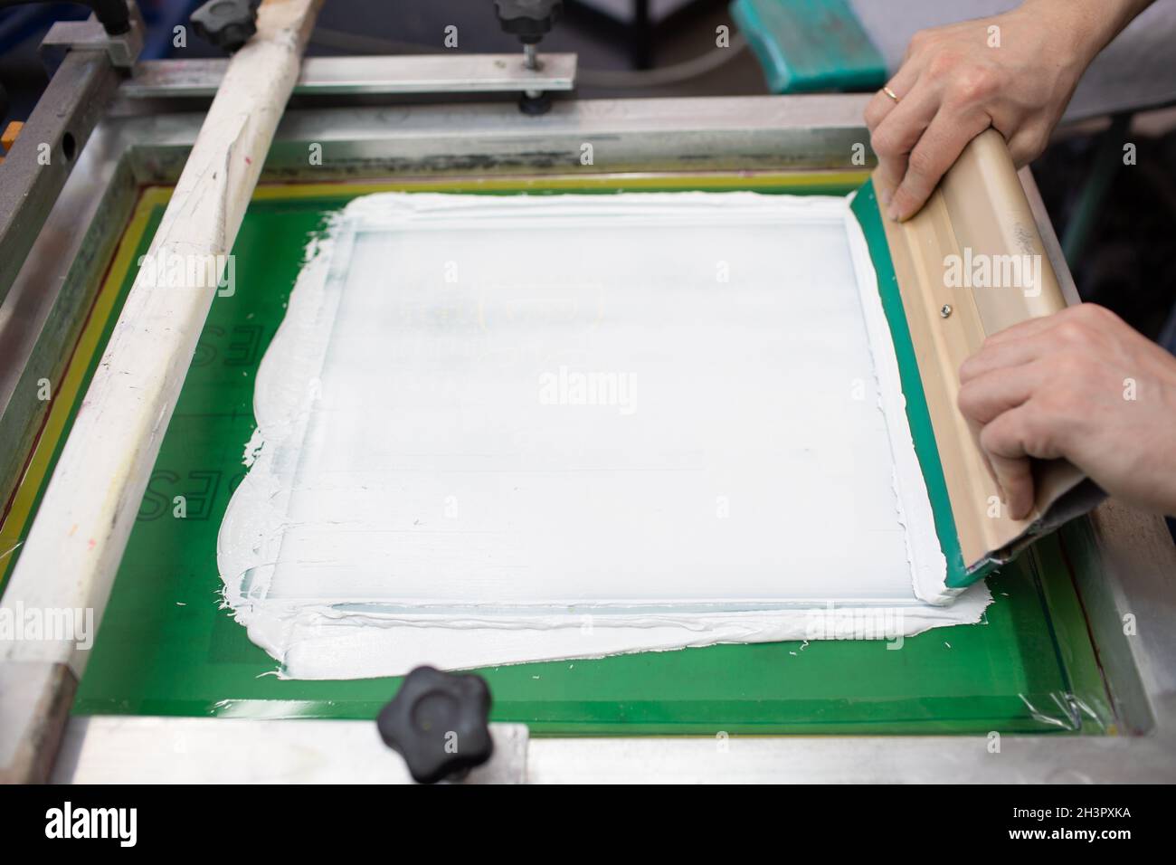 Serigraphy silk screen print process at clothes factory. Frame ...