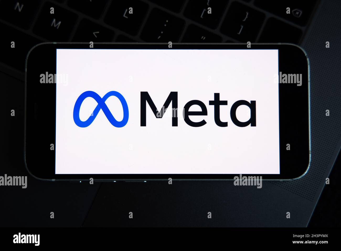 META company logo seen on smartphone in hand with Facebook logo on ...