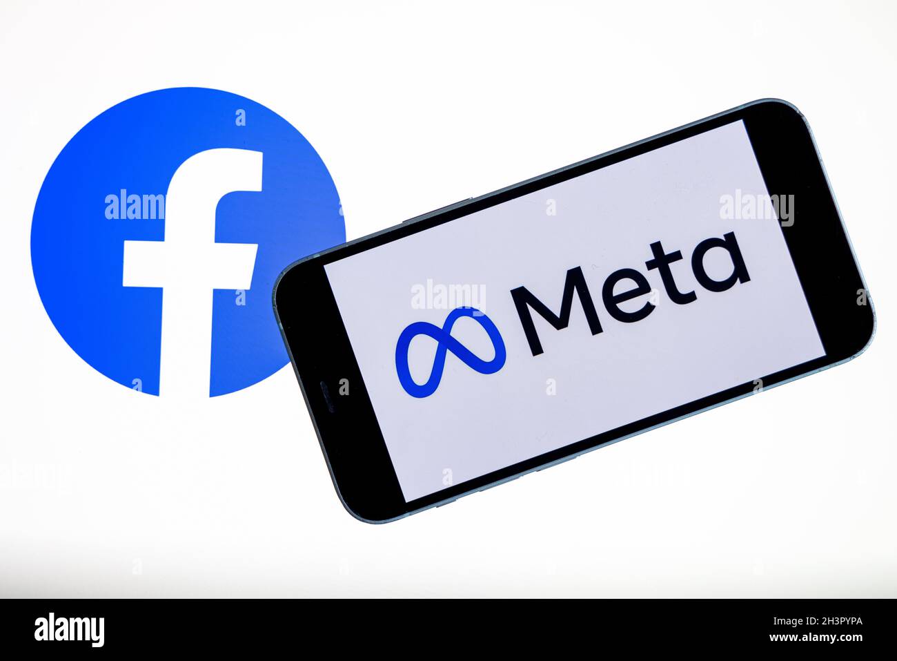 META company logo seen on smartphone in hand with Facebook logo on ...