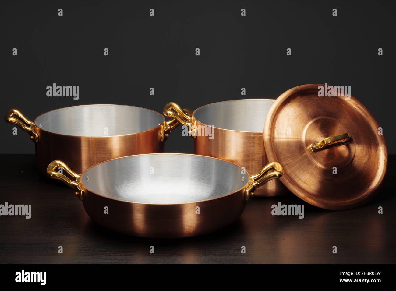 Shiny vintage copper cookware over dark background Stock Photo - Alamy