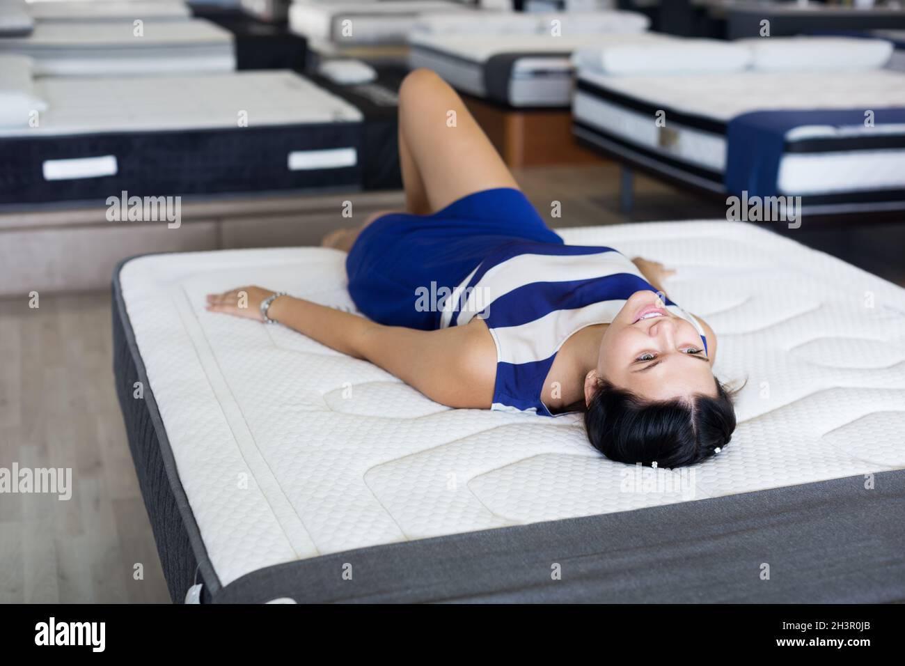 Female lying on new mattress in the furniture shop Stock Photo - Alamy