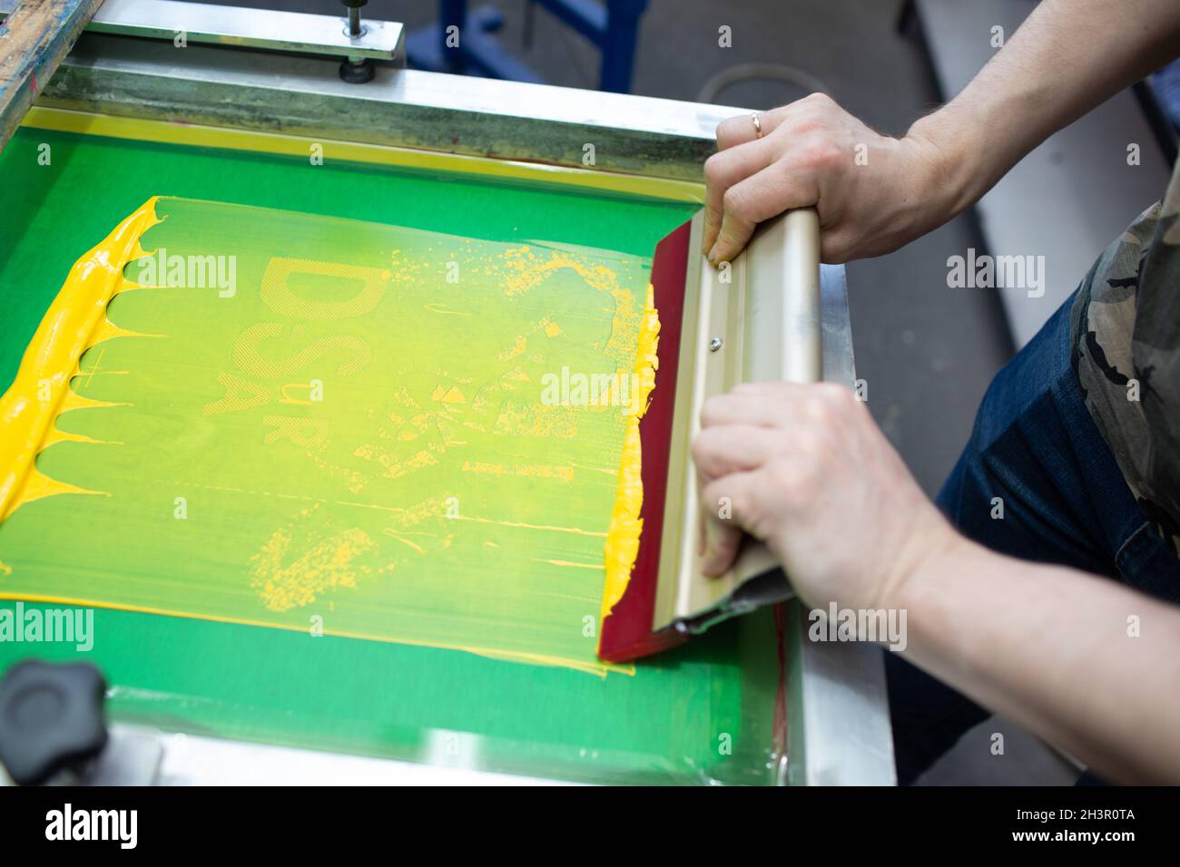 Serigraphy silk screen print process at clothes factory. Frame ...