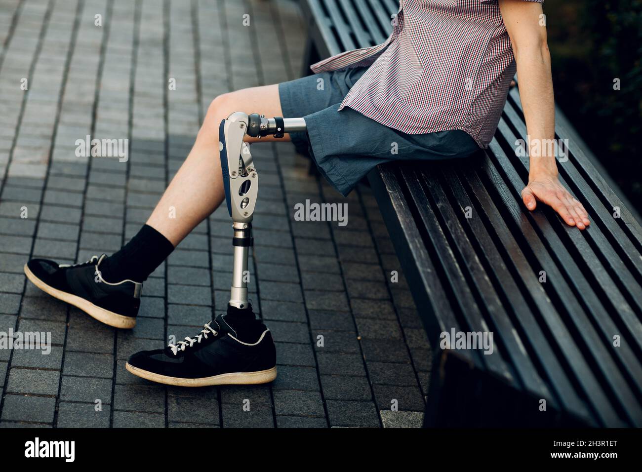 Disabled young man with foot prosthesis sitting outdoor Stock Photo - Alamy