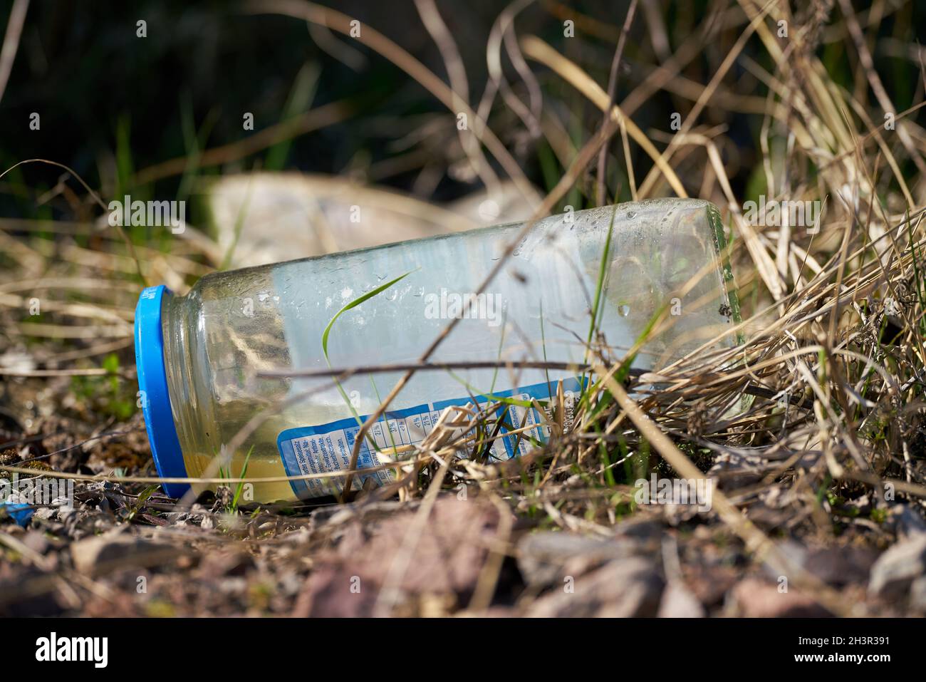 Empty sausage jar as garbage on a meadow in the city center of ...
