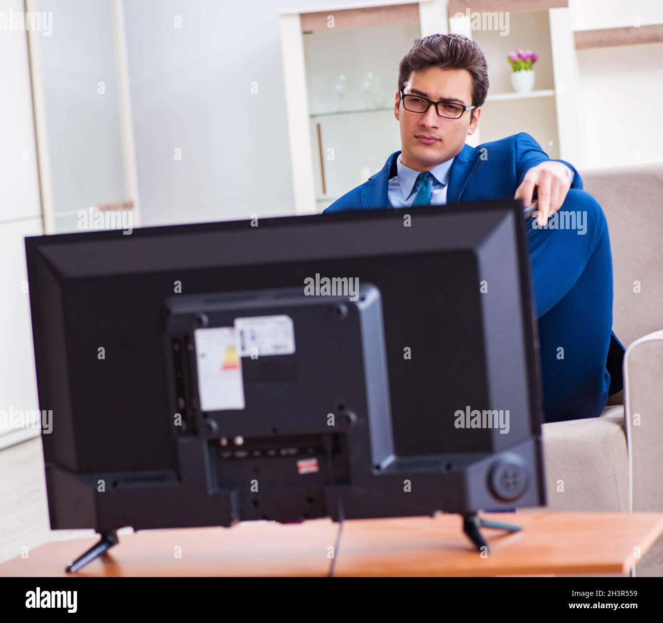 Businesman watching tv in office Stock Photo - Alamy