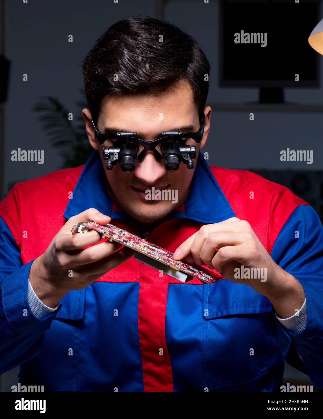 Computer specialist repairing PC late at night Stock Photo - Alamy