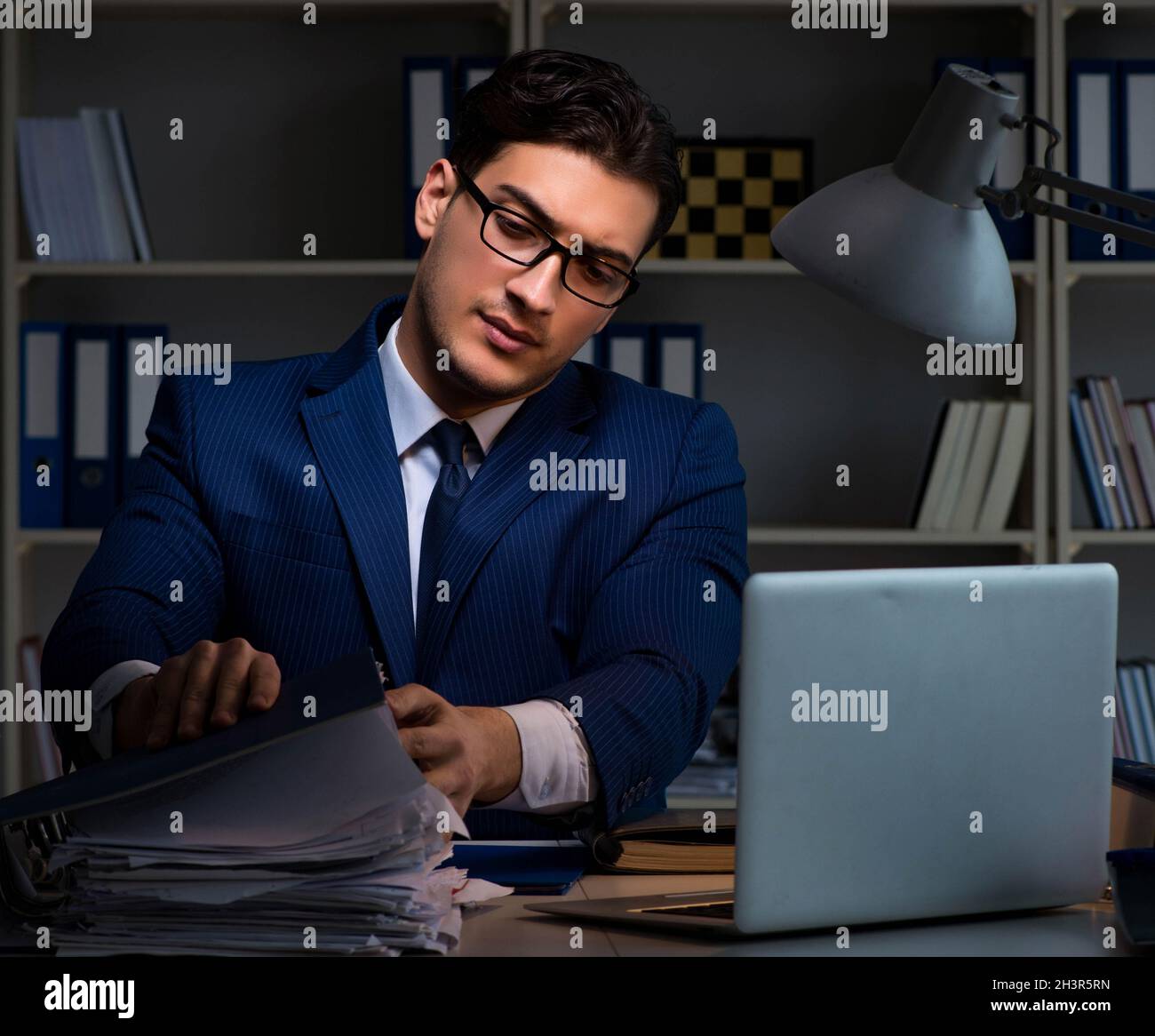 Businessman working late at night in office for overtime bonus Stock ...