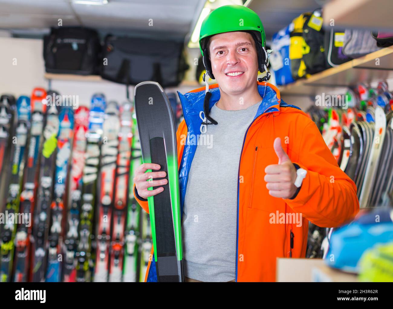 Portrait of client man in helmet and jacket who is standing with Stock ...