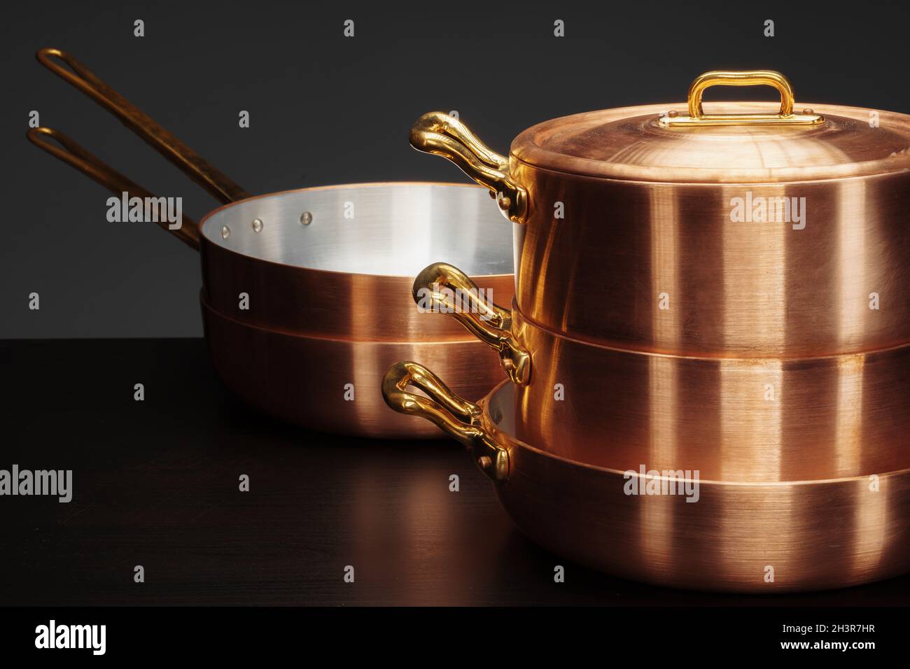 Shiny vintage copper cookware over dark background Stock Photo - Alamy