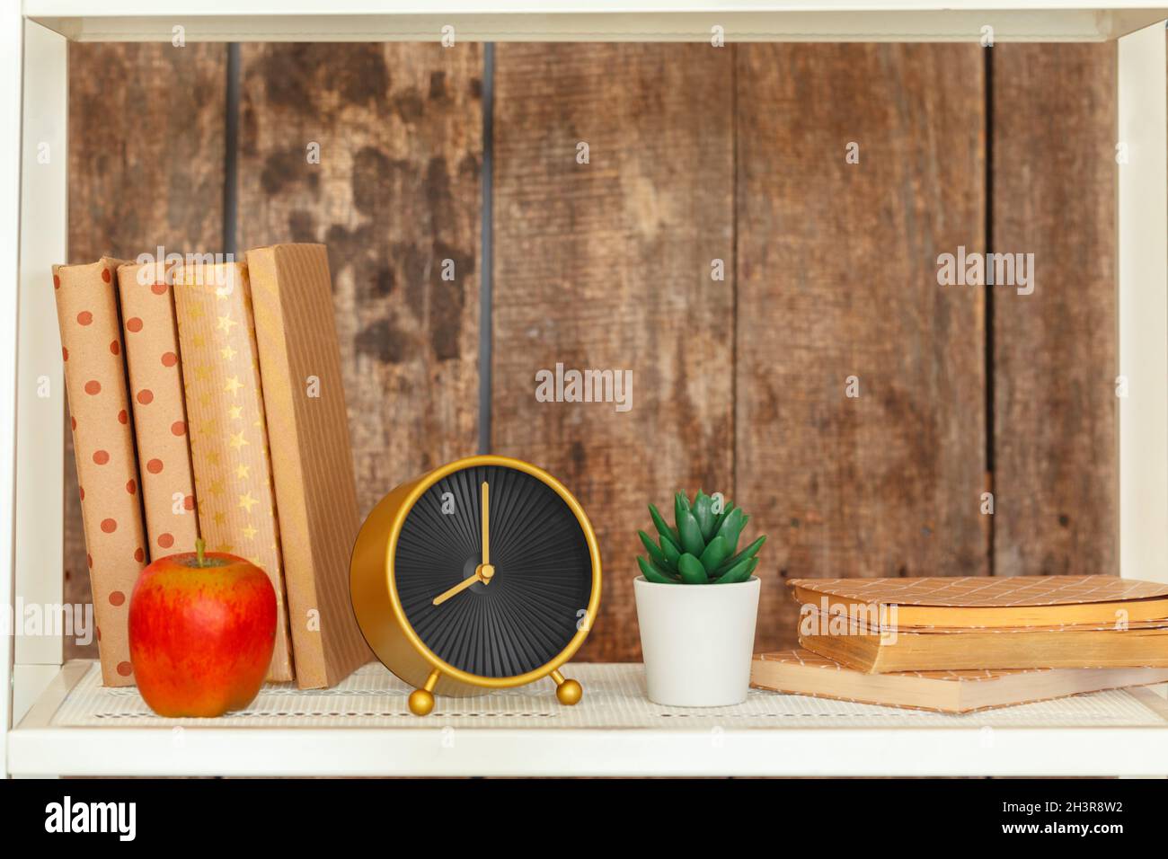 Stylish white bookshelf against grunge wooden wall Stock Photo - Alamy