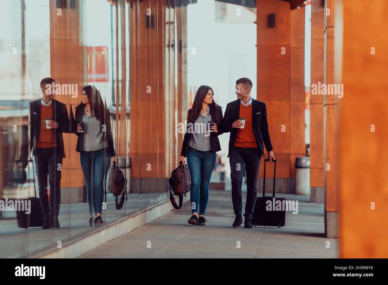 Two businessmen walk around town drinking coffee Stock Photo - Alamy