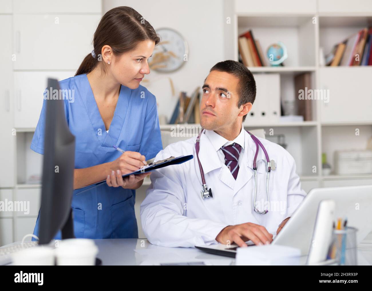 Doctor and nurse check patient data in computer database Stock Photo ...