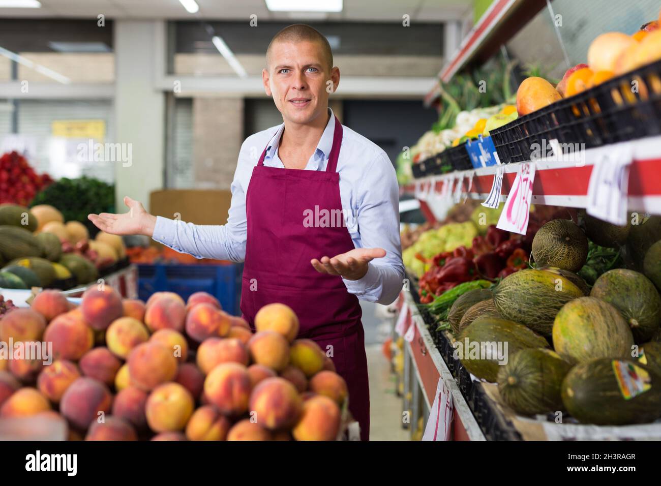 Successful salesman inviting to fruit and vegetable store Stock Photo ...