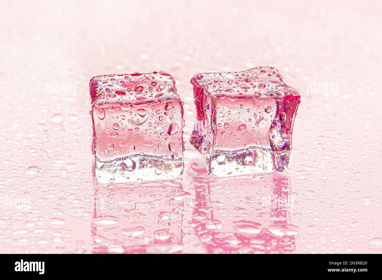 Fozen ice cubes on wet pink background Stock Photo - Alamy