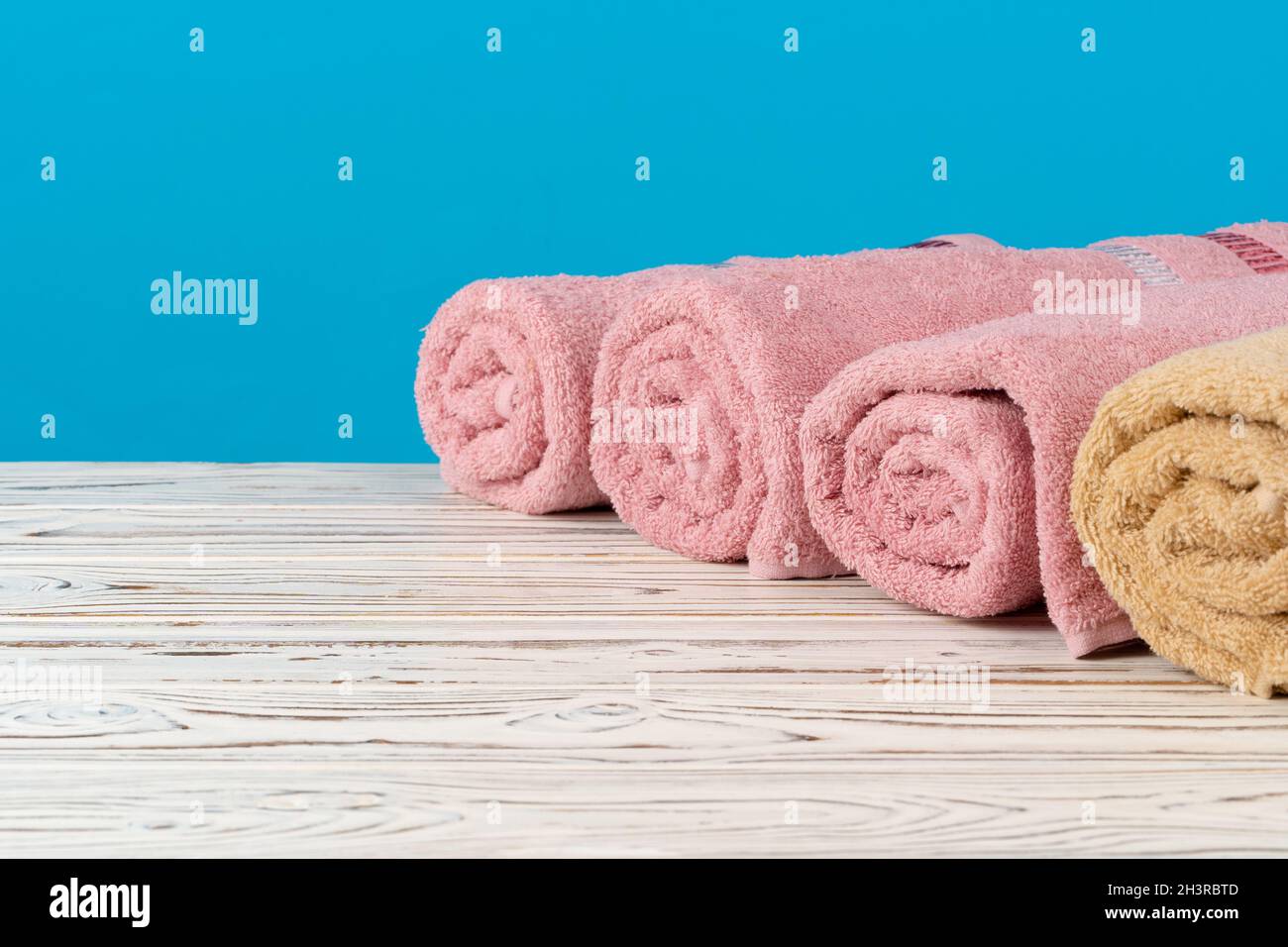 Stack of rolled towels on a wooden table Stock Photo - Alamy