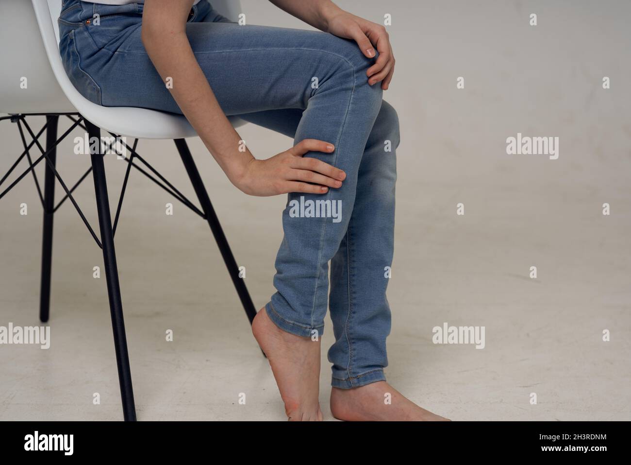 woman sitting on a chair and leg pain joint health problems Stock Photo ...