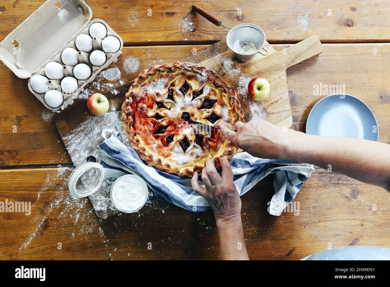 Crop person cutting pie on table Stock Photo - Alamy
