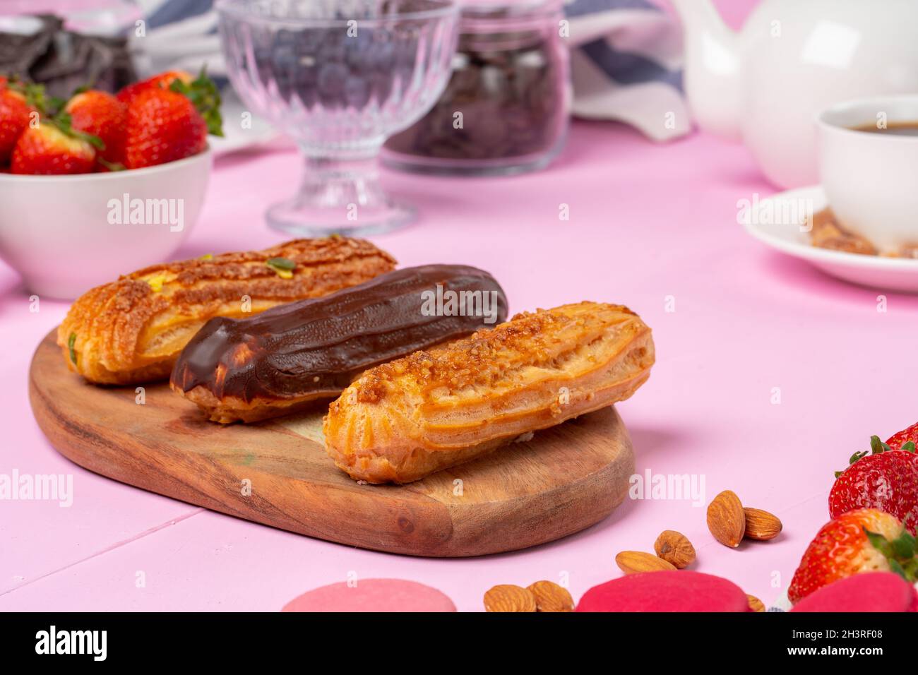 Home made cake eclairs on pink table Stock Photo - Alamy