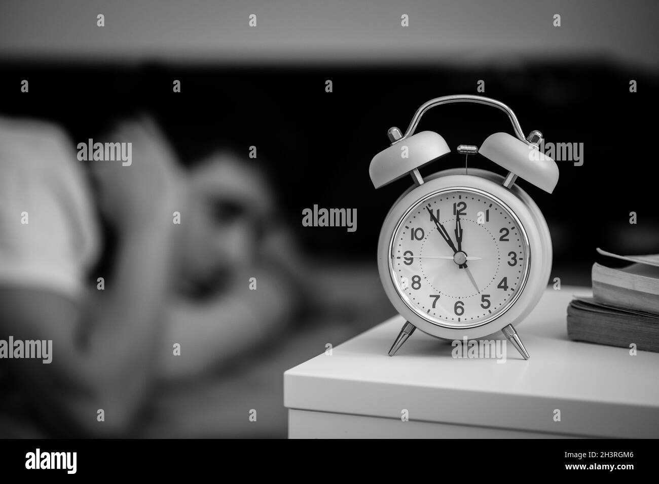 Alarm clock in the morning. Young man tries to sleep in the blurry ...