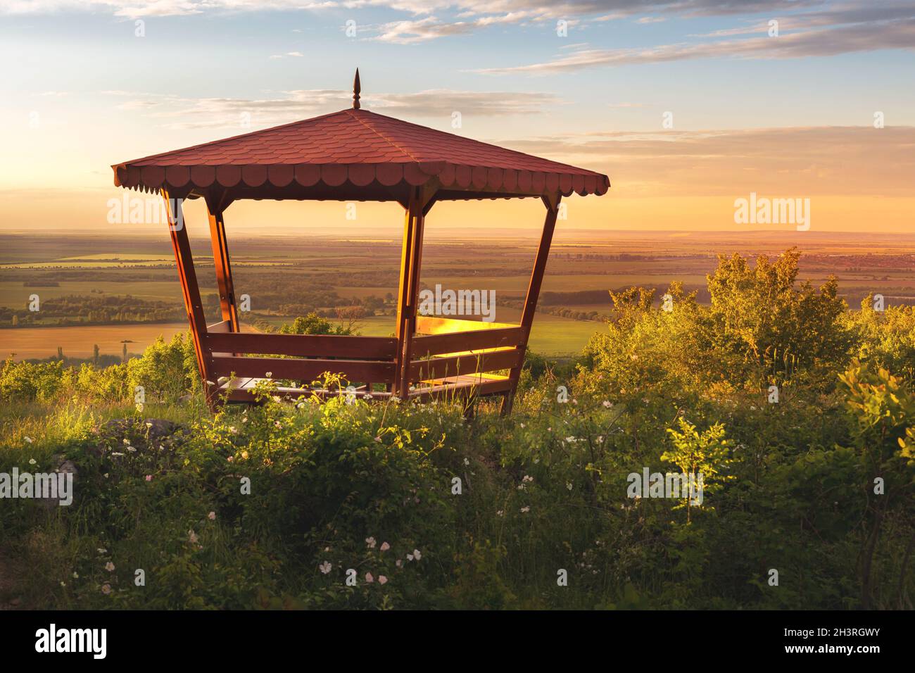 Wooden gazebo over summer sunset landscape Stock Photo - Alamy