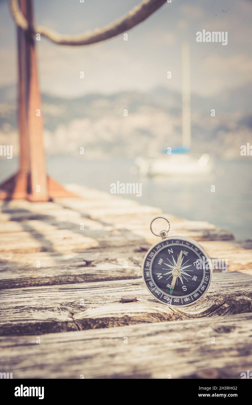 Sailing: nautical compass on wooden dock pier. Sailing boats in the ...