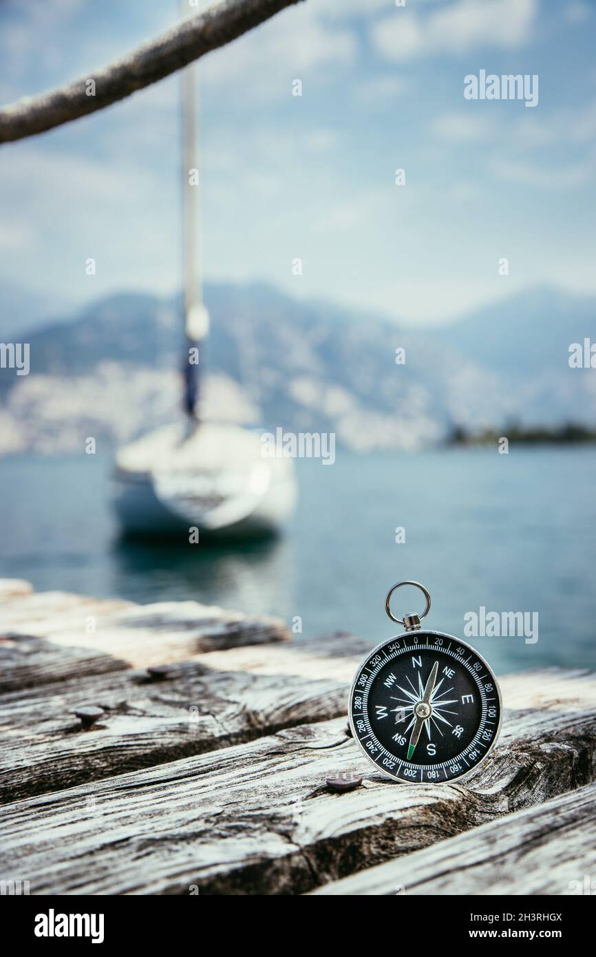 Sailing: nautical compass on wooden dock pier. Sailing boats in the ...