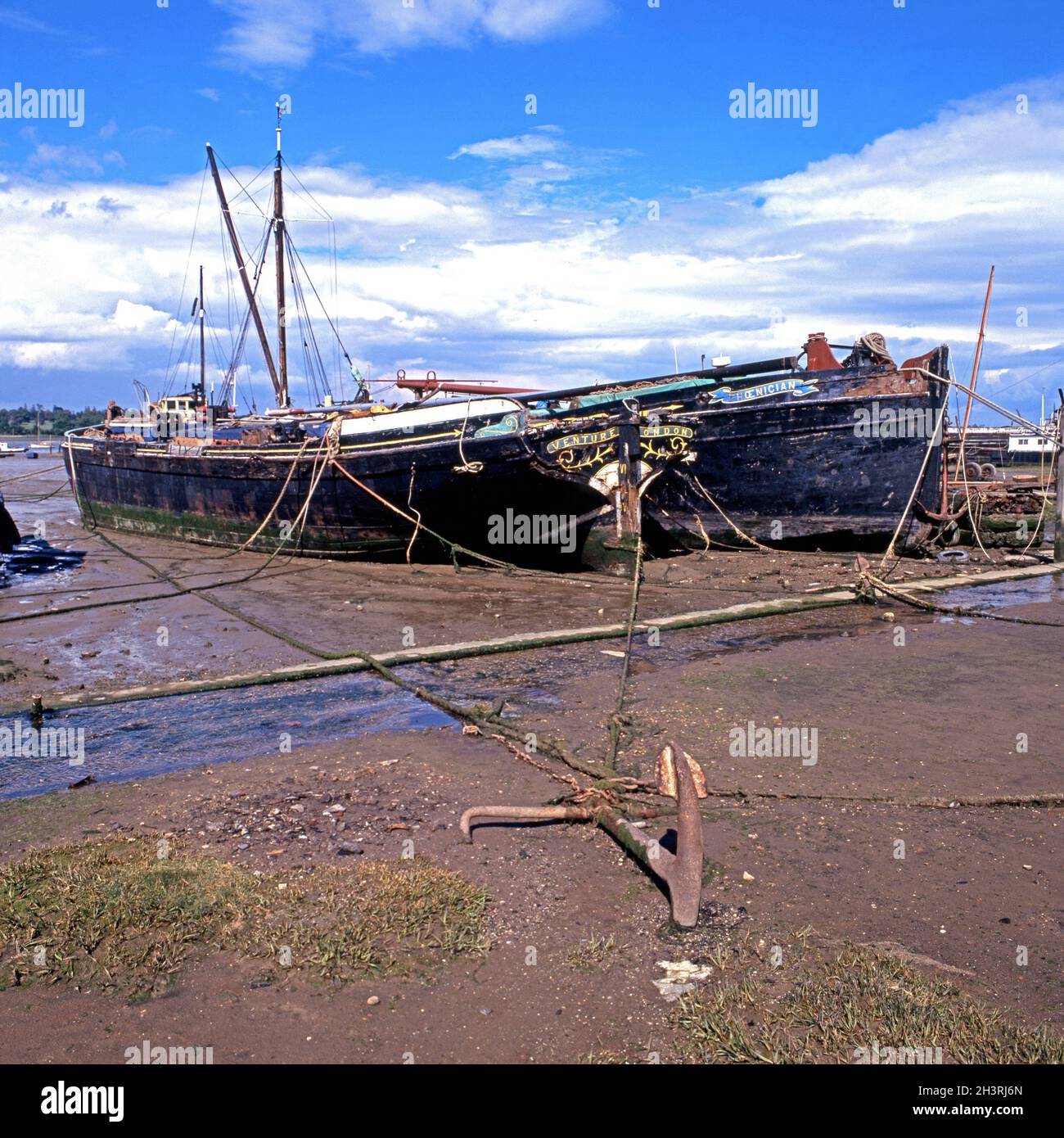 Thames barges on the River Orwell shoreline at low tide, Pin Mill, UK ...