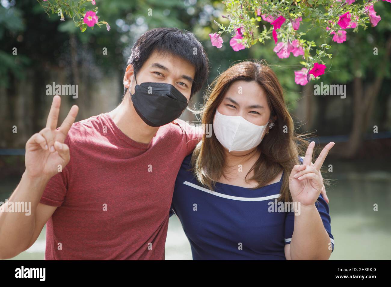 asian couple wearing protection face mask hand sign victory standing ...