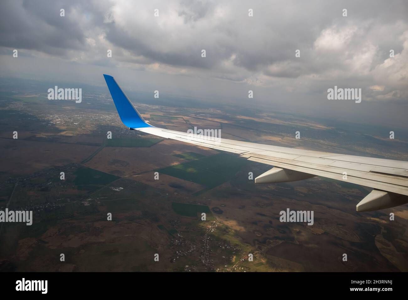 View of jet airplane wing landing at airport in bad weather. Travel and ...