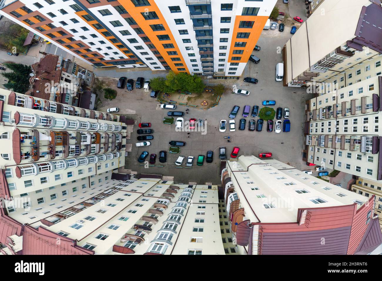 Aerial view of parked cars on parking lot between high apartment ...