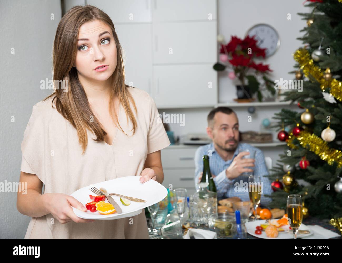 Upset woman clearing table Stock Photo - Alamy