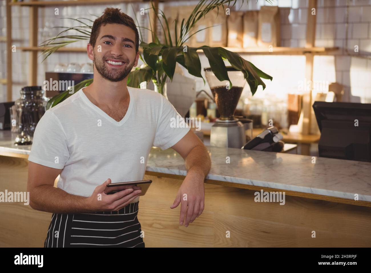 Portrait of waiter with tablet by counter at cafe Stock Photo - Alamy