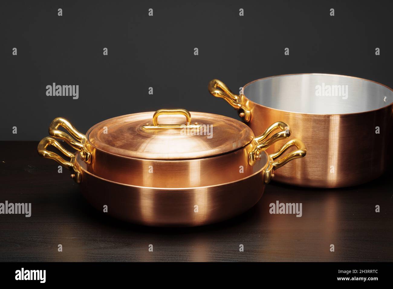 Shiny vintage copper cookware over dark background Stock Photo - Alamy