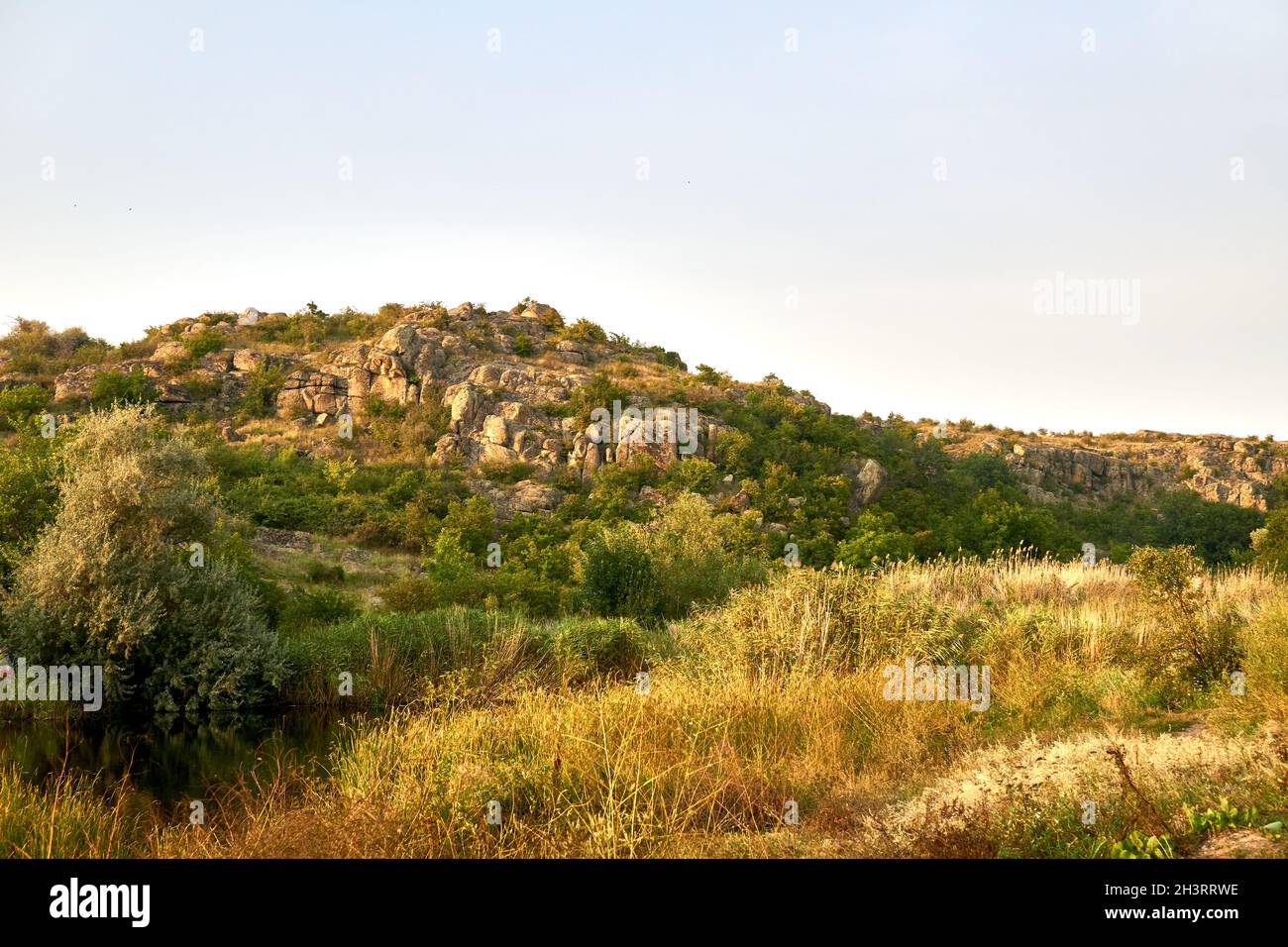 Rocky hills and dense green vegetation at dusk Stock Photo - Alamy