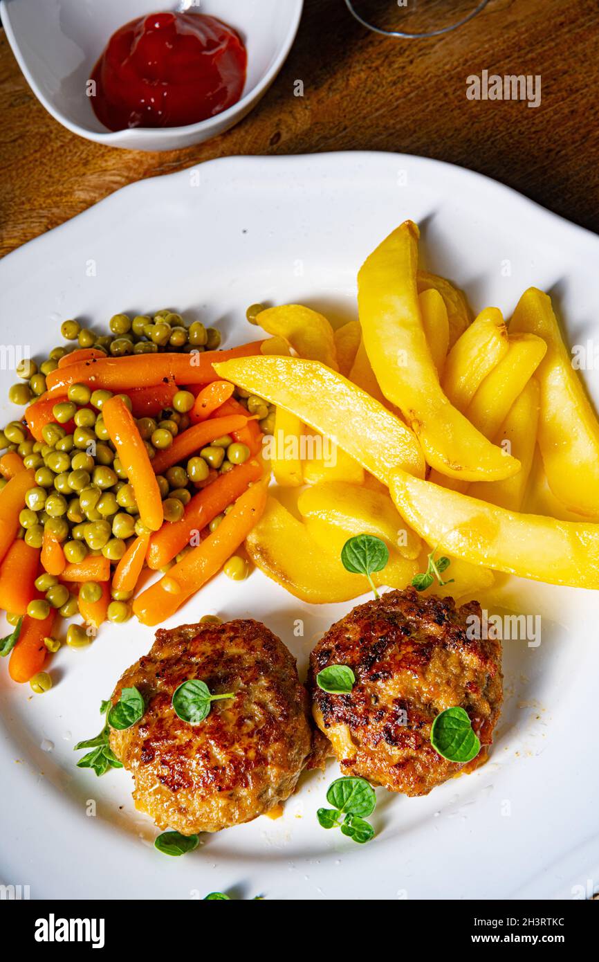 Homemade meatballs with french fries and vegetables Stock Photo - Alamy