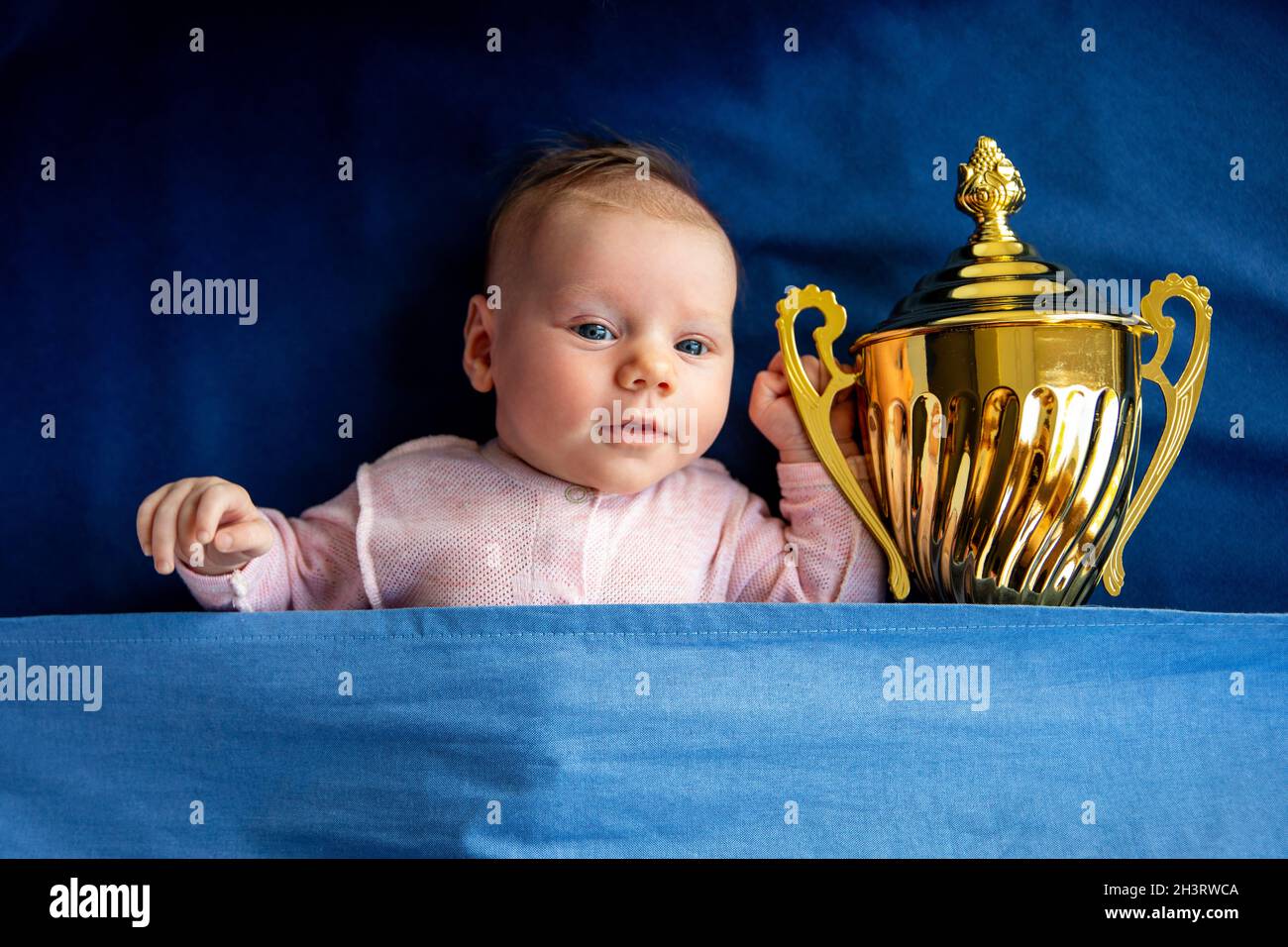 newborn baby looking into camera, little girl with golden cup, victory ...