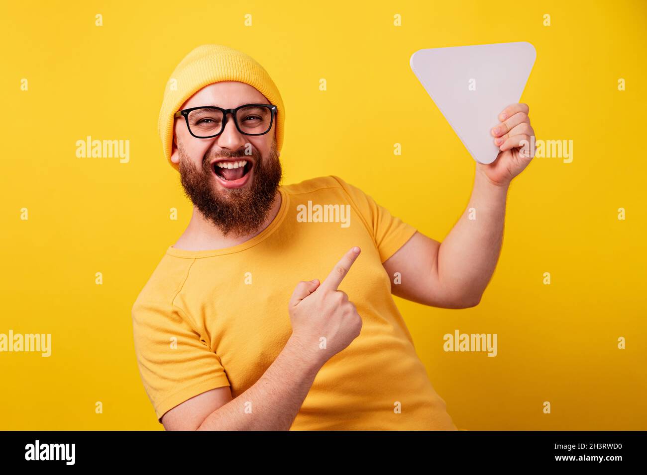 smiling man pointing at play button sign over yellow background ...