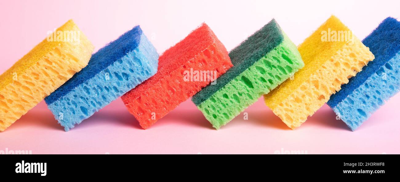 multi-colored washing sponges over pink background, panoramic image ...