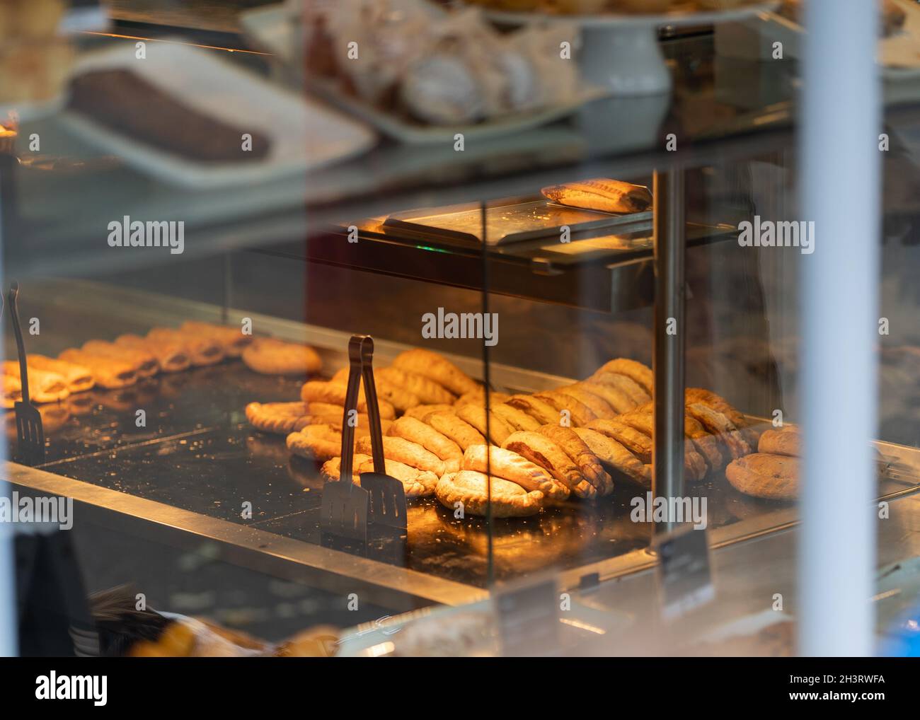 Delicious traditional Cornish pasty pies cooking and on display in shop ...