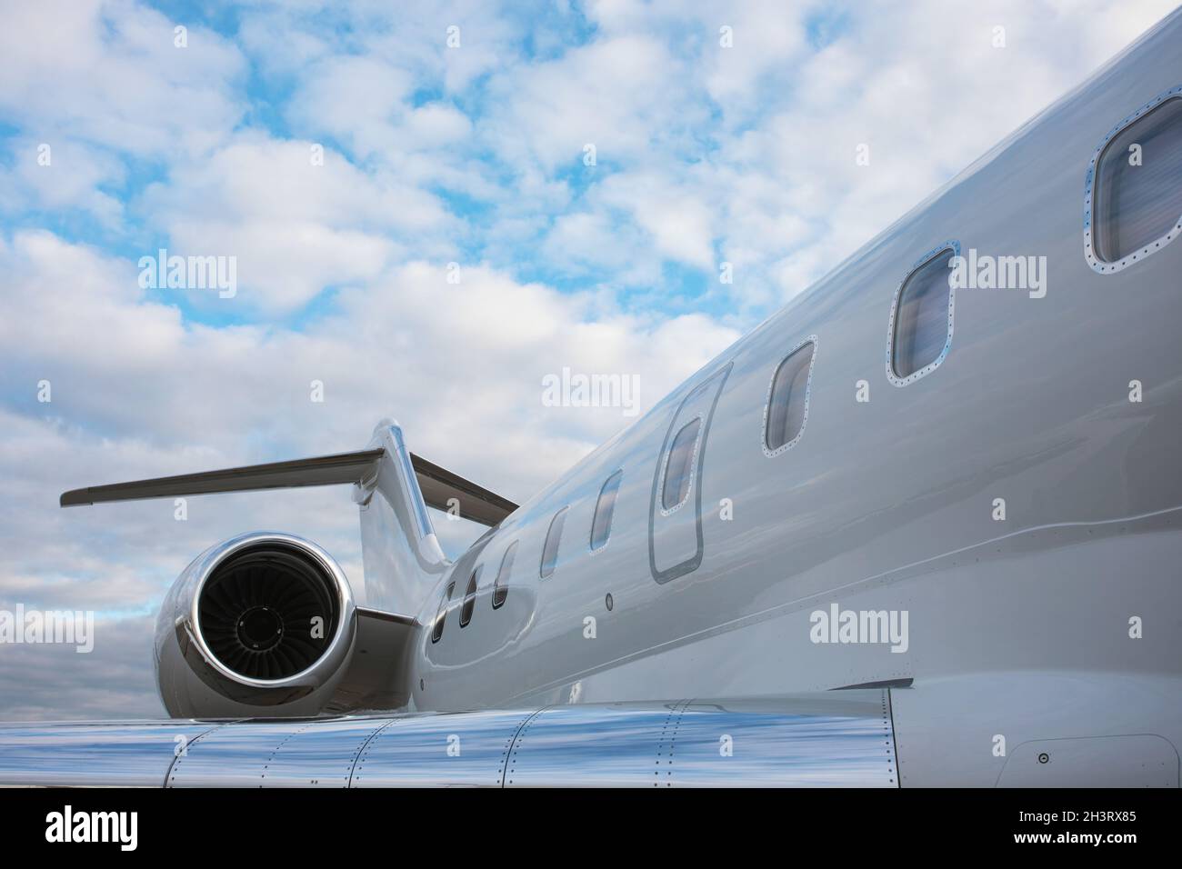part of modern private jet airplane with a tail and wing over sky ...