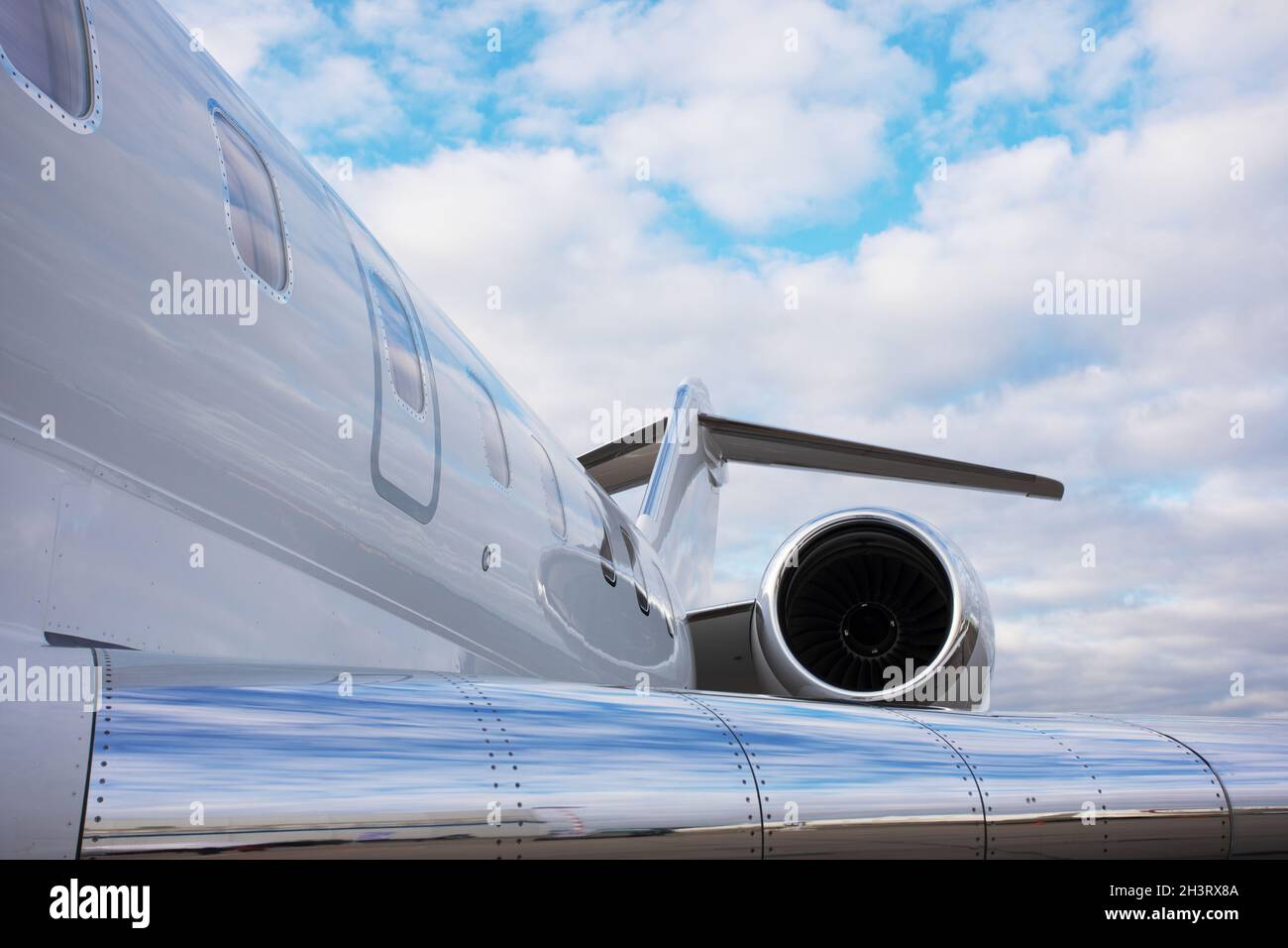 part of modern private jet airplane with a tail and wing over sky ...