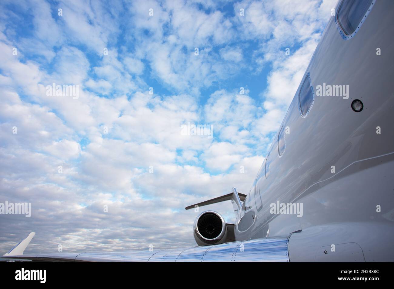 part of modern private jet airplane with a tail and wing over sky ...