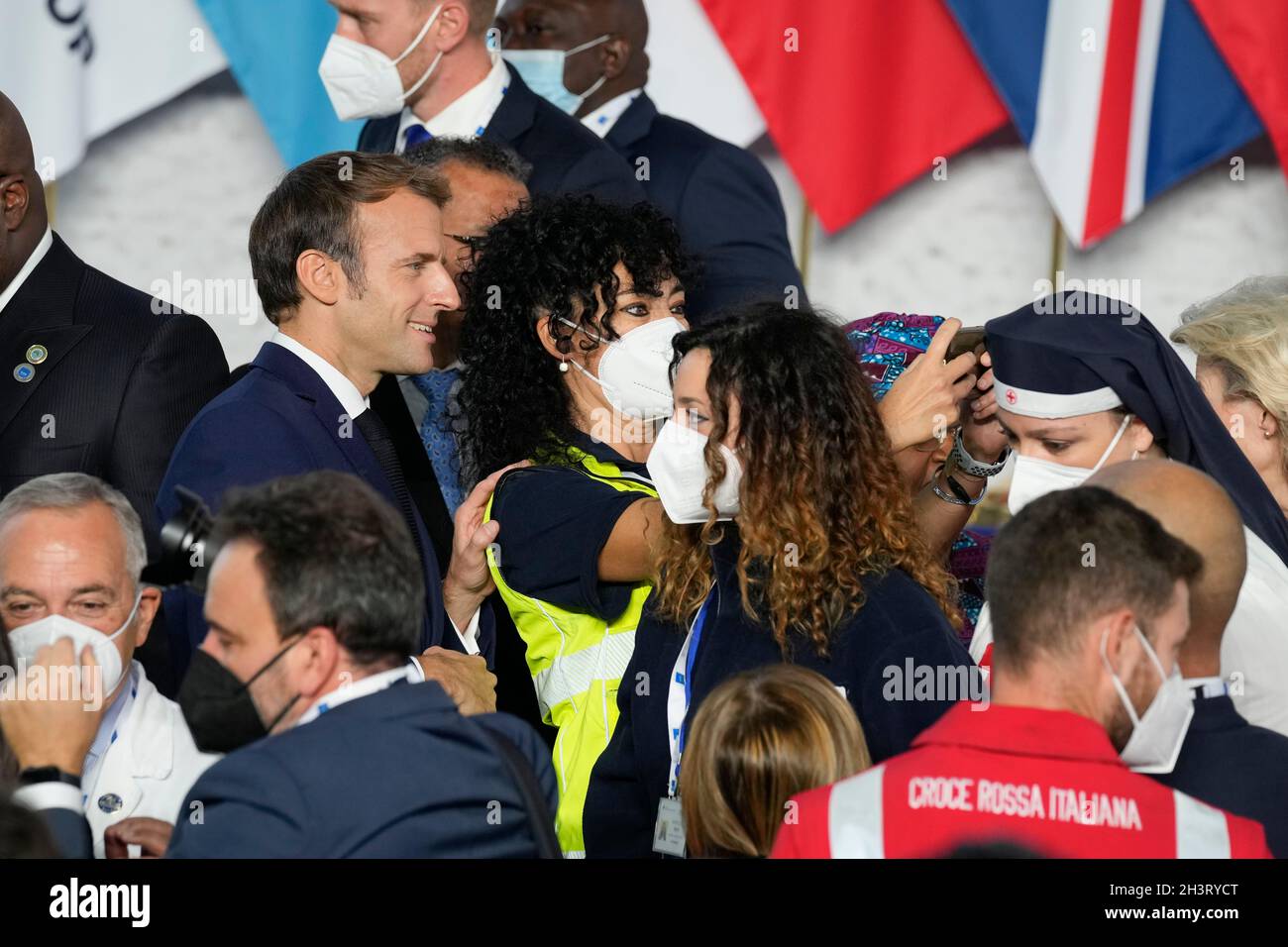 French President Emmanuel Macron poses for a selfie with medical ...