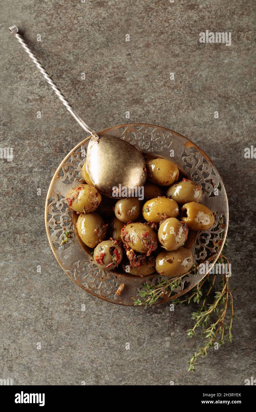 Spicy green olives in olive oil on a old stone table. Top view Stock ...