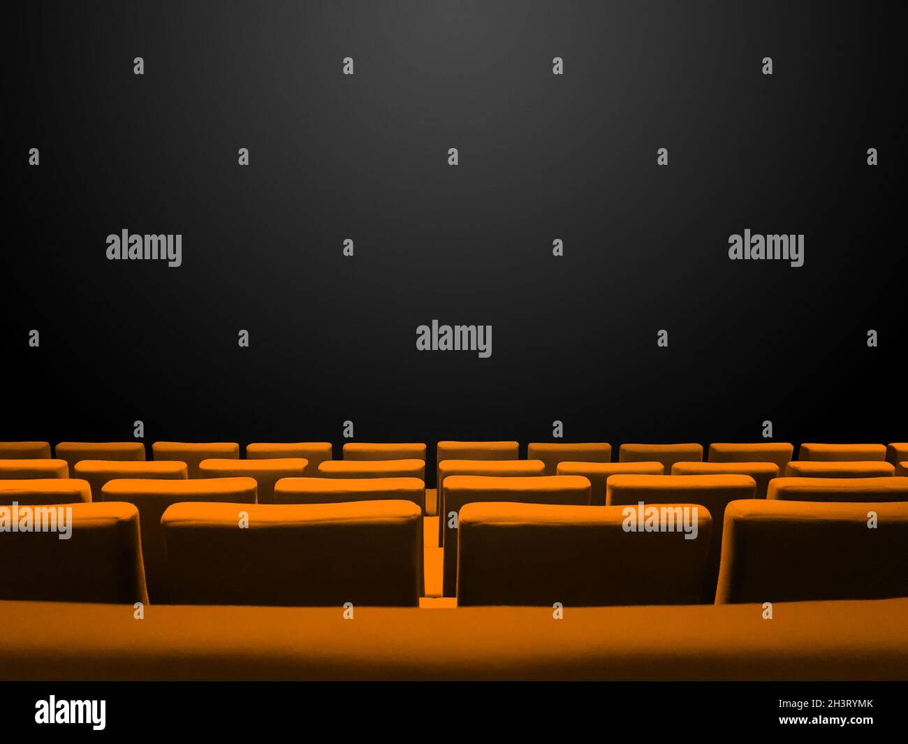 Cinema movie theatre with orange seats rows and a black background ...
