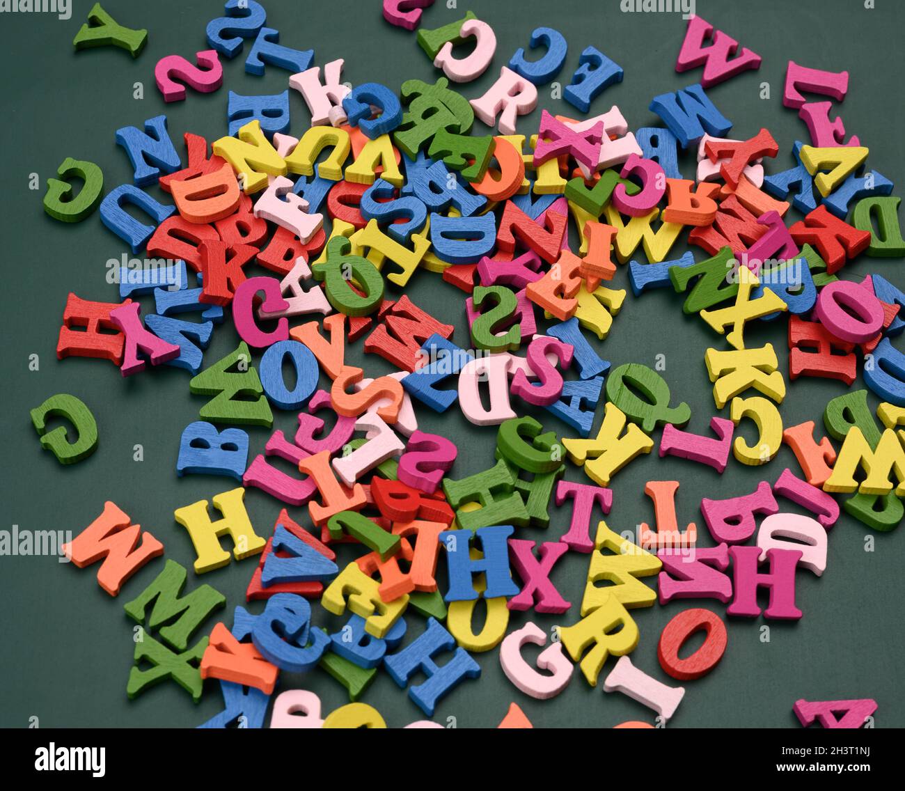 Multicolored wooden letters of the english alphabet on a green ...