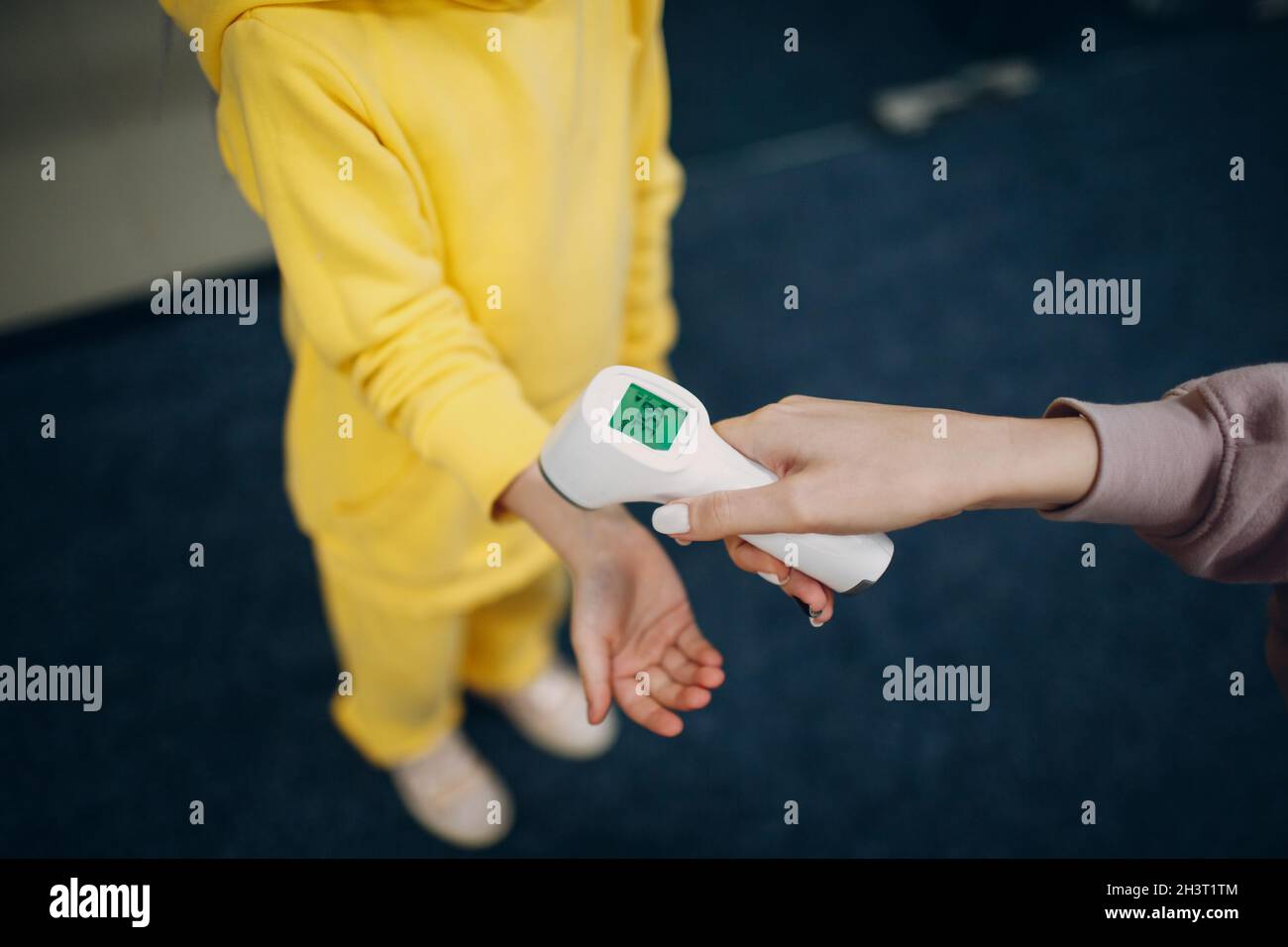 Child hand temperature measurement check by laser thermometer at ...