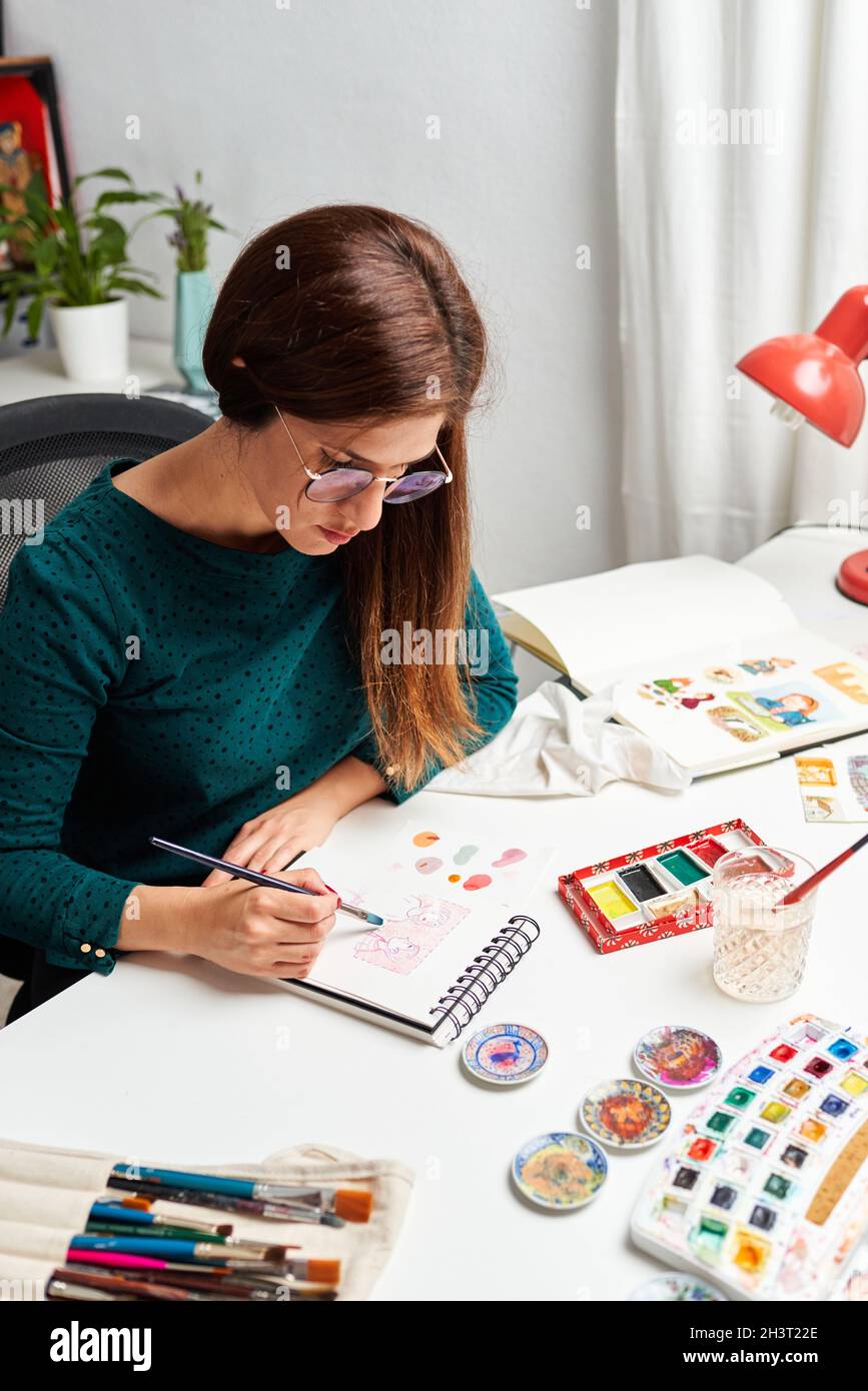 Illustrator painting at work desk hi-res stock photography and images ...