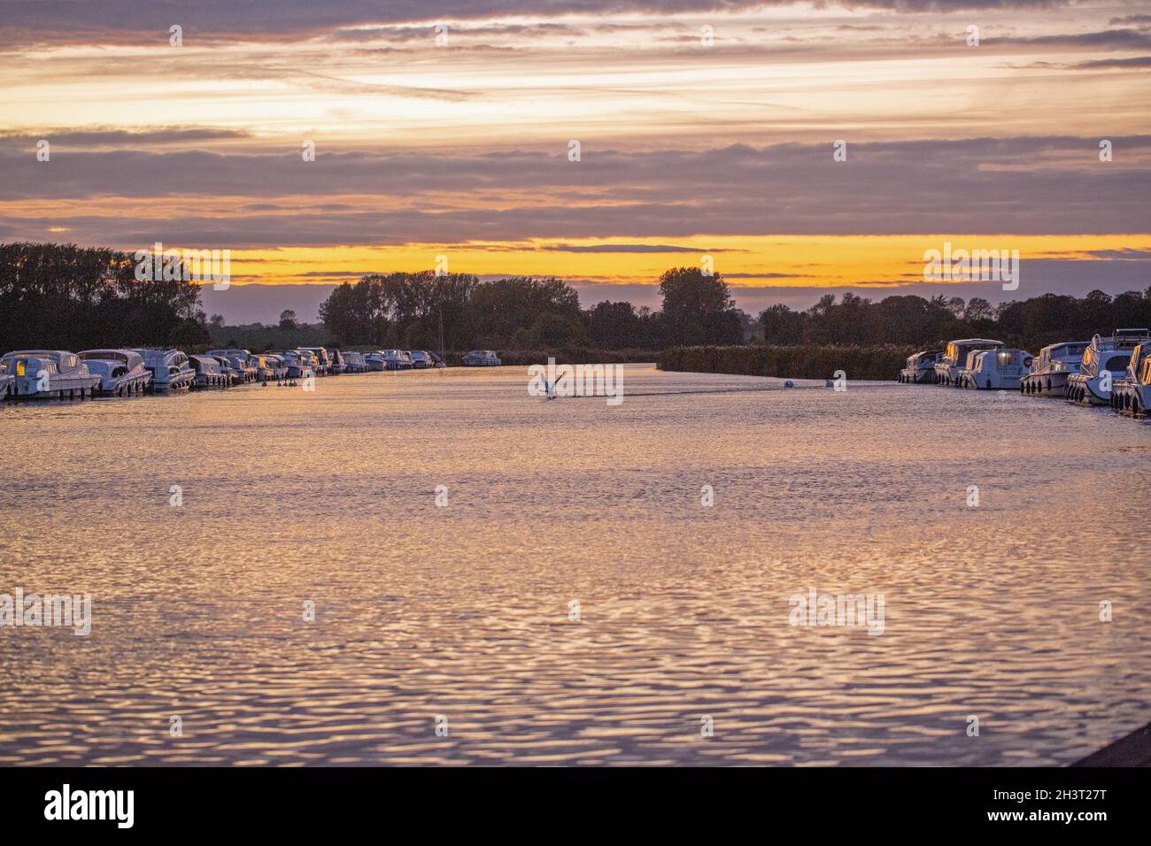 Evening sunset. Colourful cloud layers reflected on the surfaceof River ...